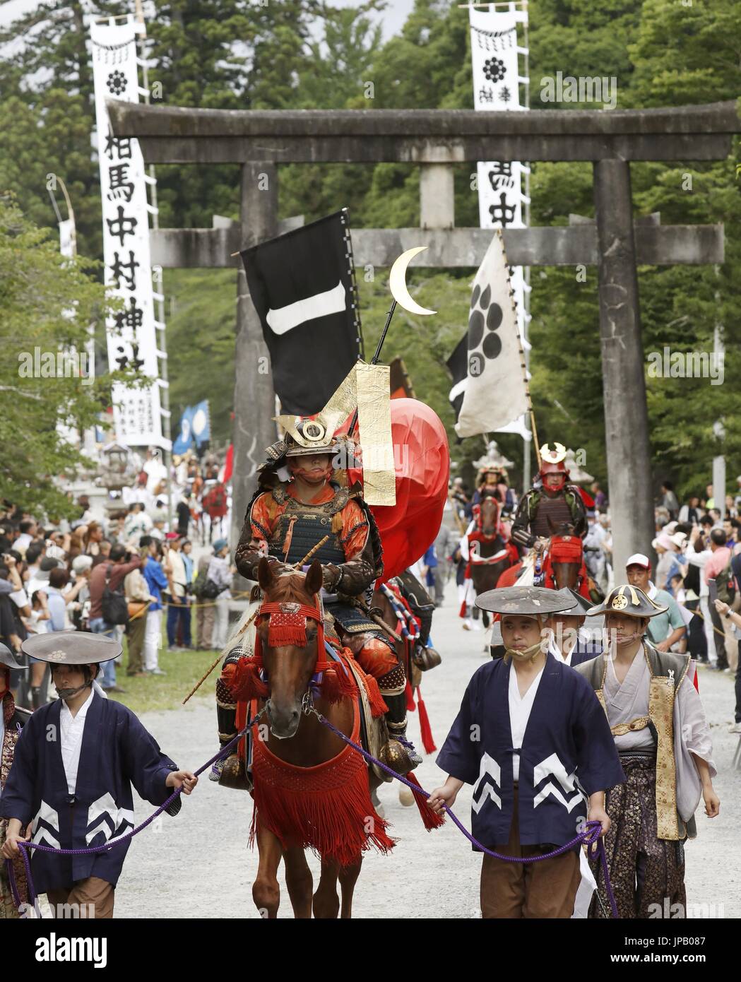 Men dressed as armed warriors leave a shrine in a traditional parade in ...