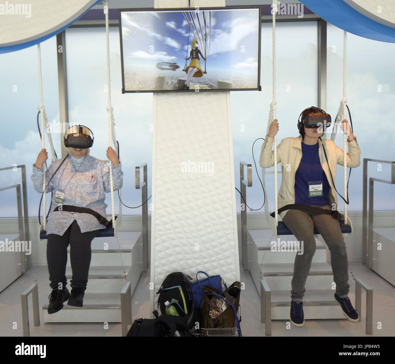Visitors wearing headsets sit on a swing-like ride at "SKY CIRCUS ...