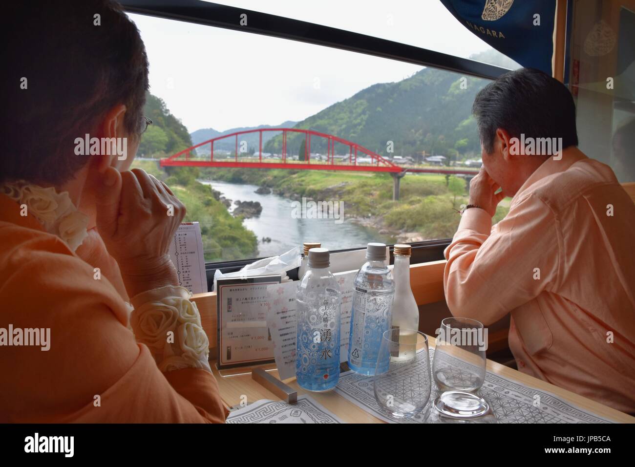 Passengers gaze at the Nagara River from inside Nagaragawa Railway's ...