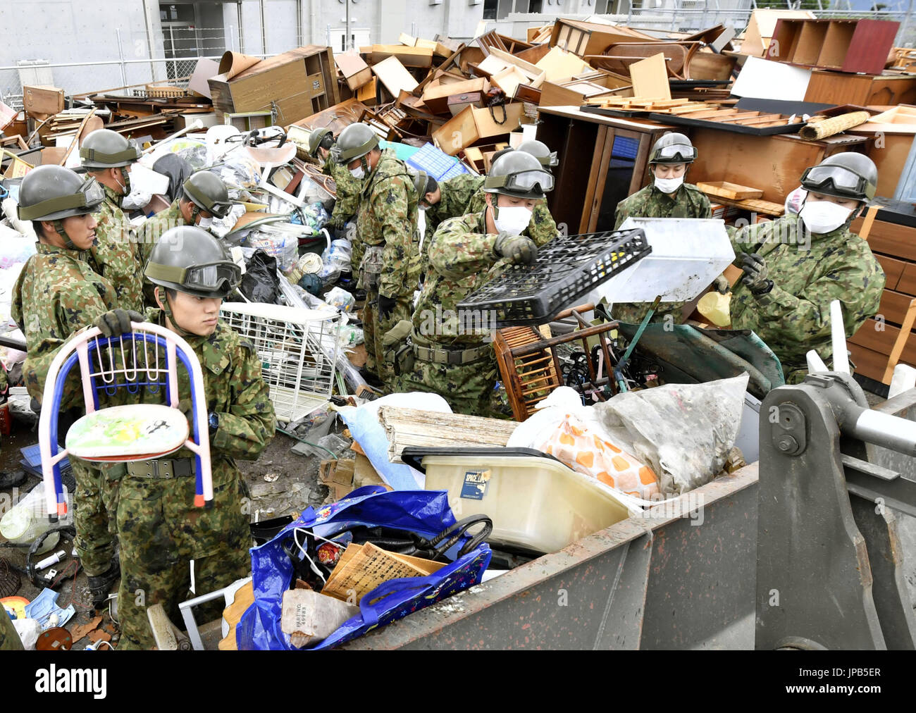About 90 Japan Self-Defense Force personnel clear away piles of rubble ...