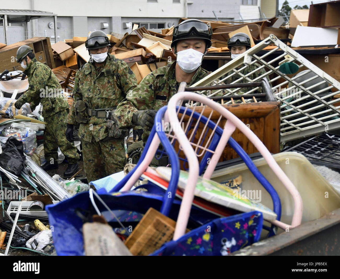 About 90 Japan Self-Defense Force personnel clear away piles of rubble ...