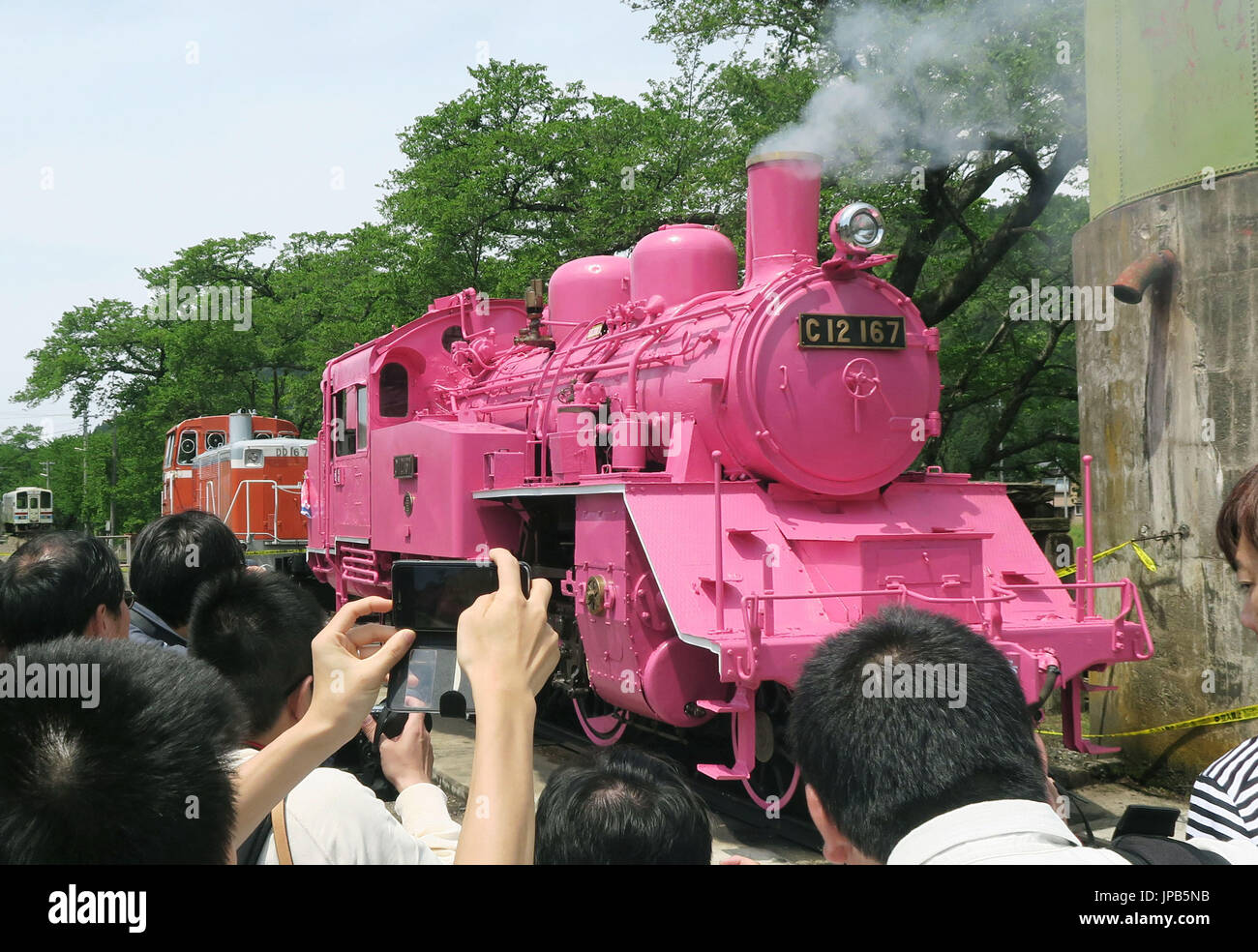 A steam locomotive painted in pink runs at a yard at Wakasa Station in ...
