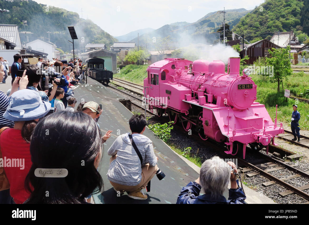 A steam locomotive painted in pink runs at a yard at Wakasa Station in ...