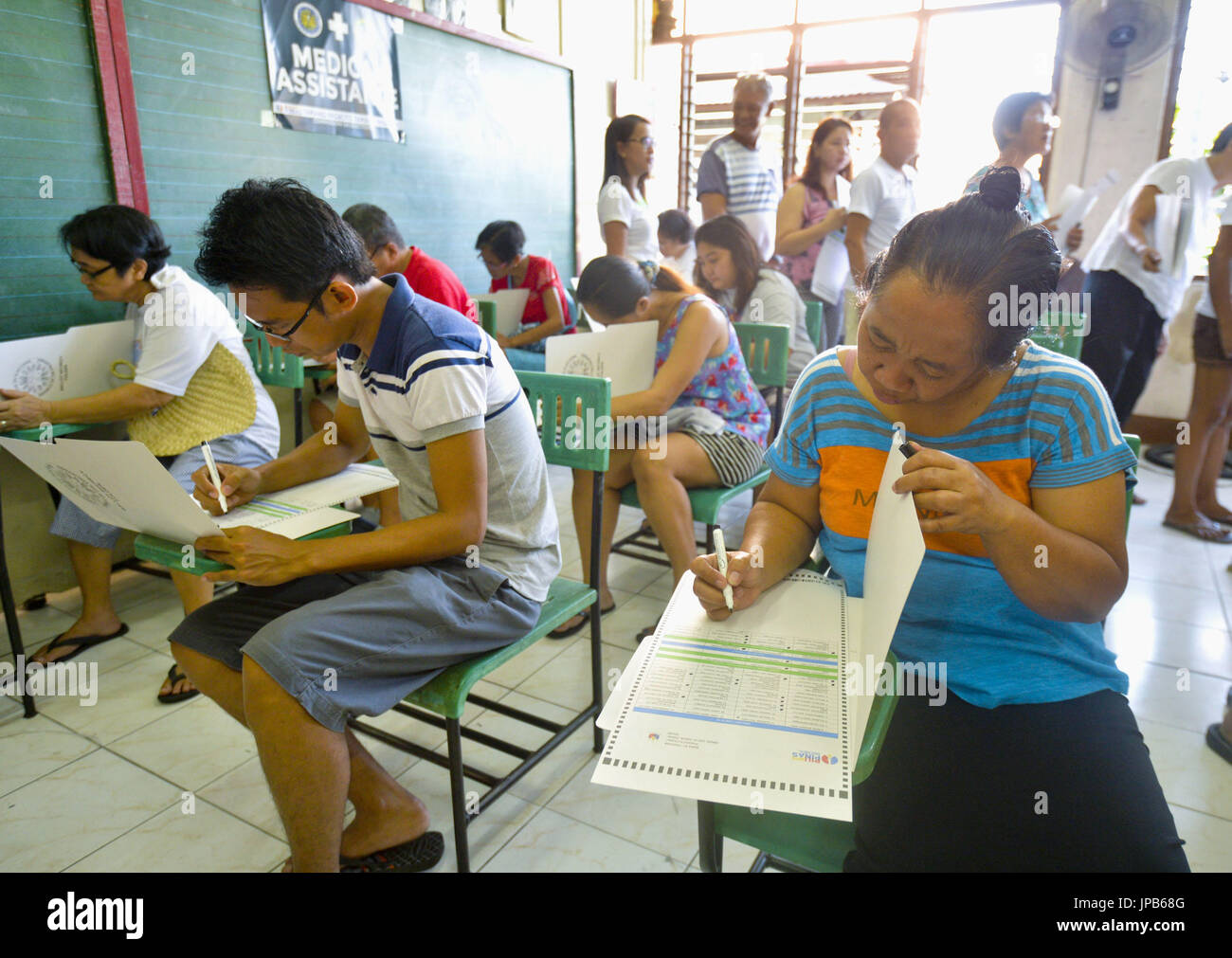 Voters fill out ballot papers in Manila on May 9, 2016, as voting in ...