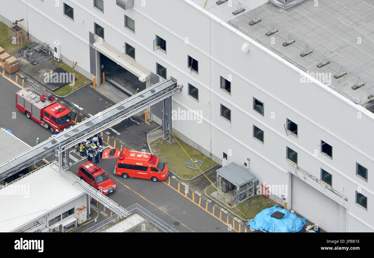 Firefighters gather at the site of an explosion at an auto parts ...