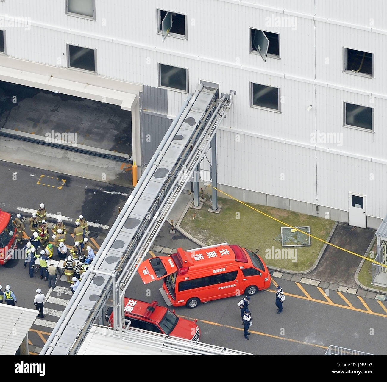 Firefighters gather at the site of an explosion at an auto parts ...
