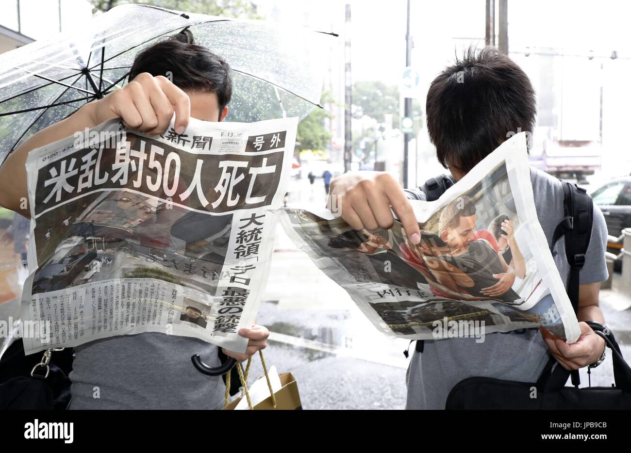 People in Tokyo read extra editions of a newspaper on June 13, 2016 ...