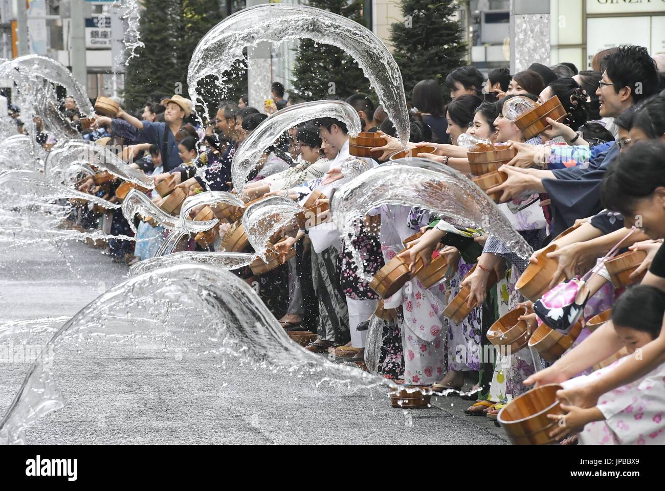 People in yukata, a casual summer version of kimono, splash water on a ...