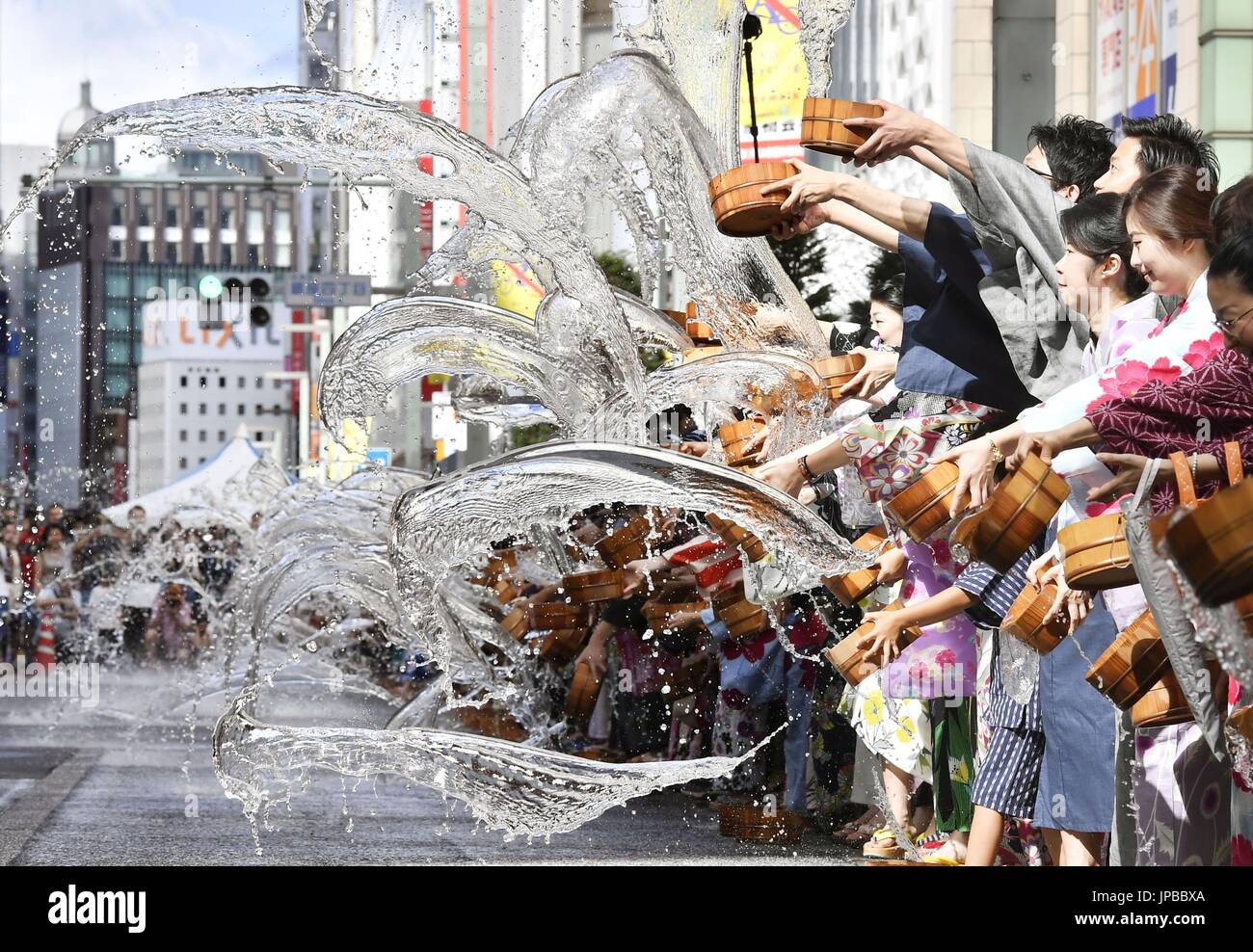 People in yukata, a casual summer version of kimono, splash water on a ...