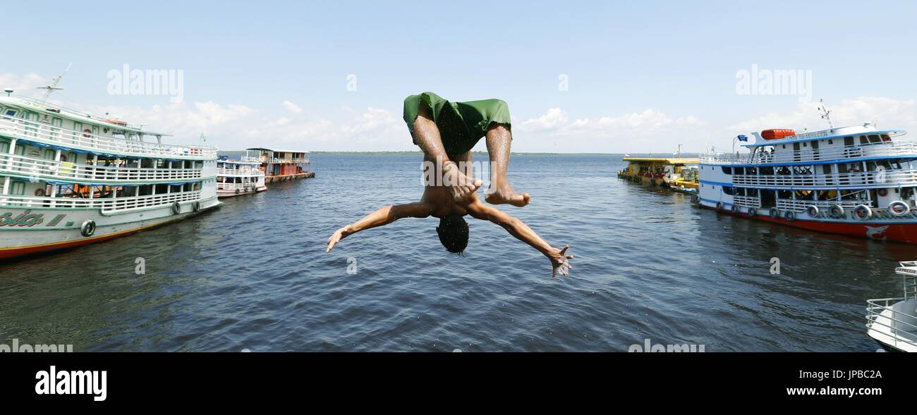 A boy jumps into the Negro River in Manaus, Brazil, on July 31, 2016 ...