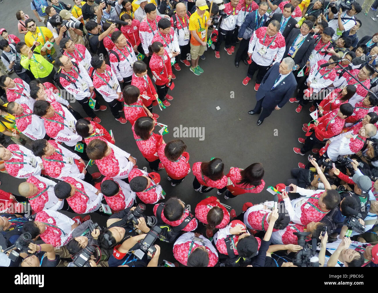 Japanese athletes form multiple rings to encircle and hear words of ...