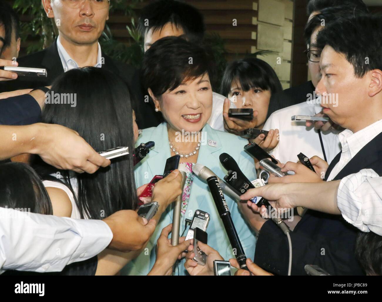 New Tokyo Gov. Yuriko Koike is surrounded by reporters after meeting ...