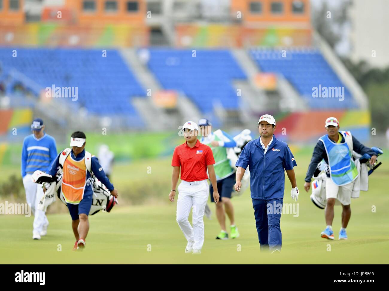 Japan's Yuta Ikeda (2nd from R) walks on the first-hole fairway in the second round of the men's ...