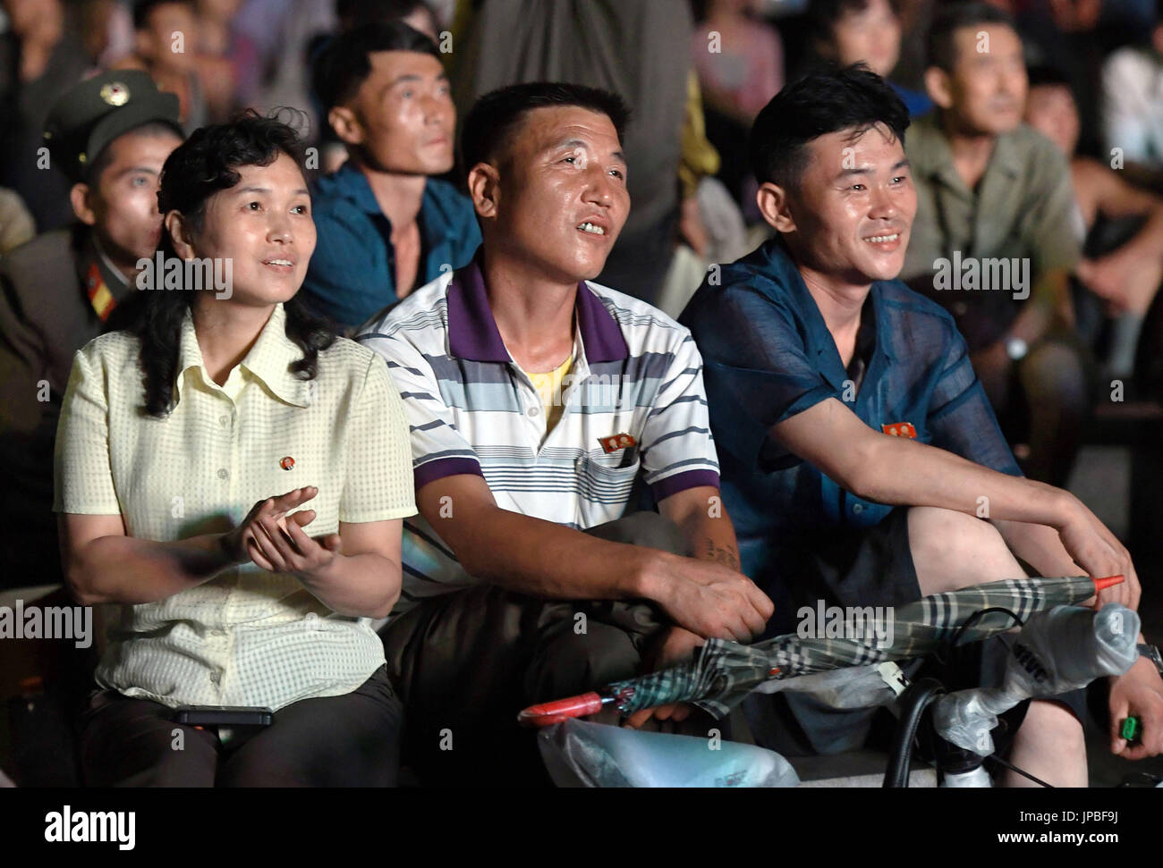 People in Pyongyang watch a large screen showing weightlifter Rim Jong ...