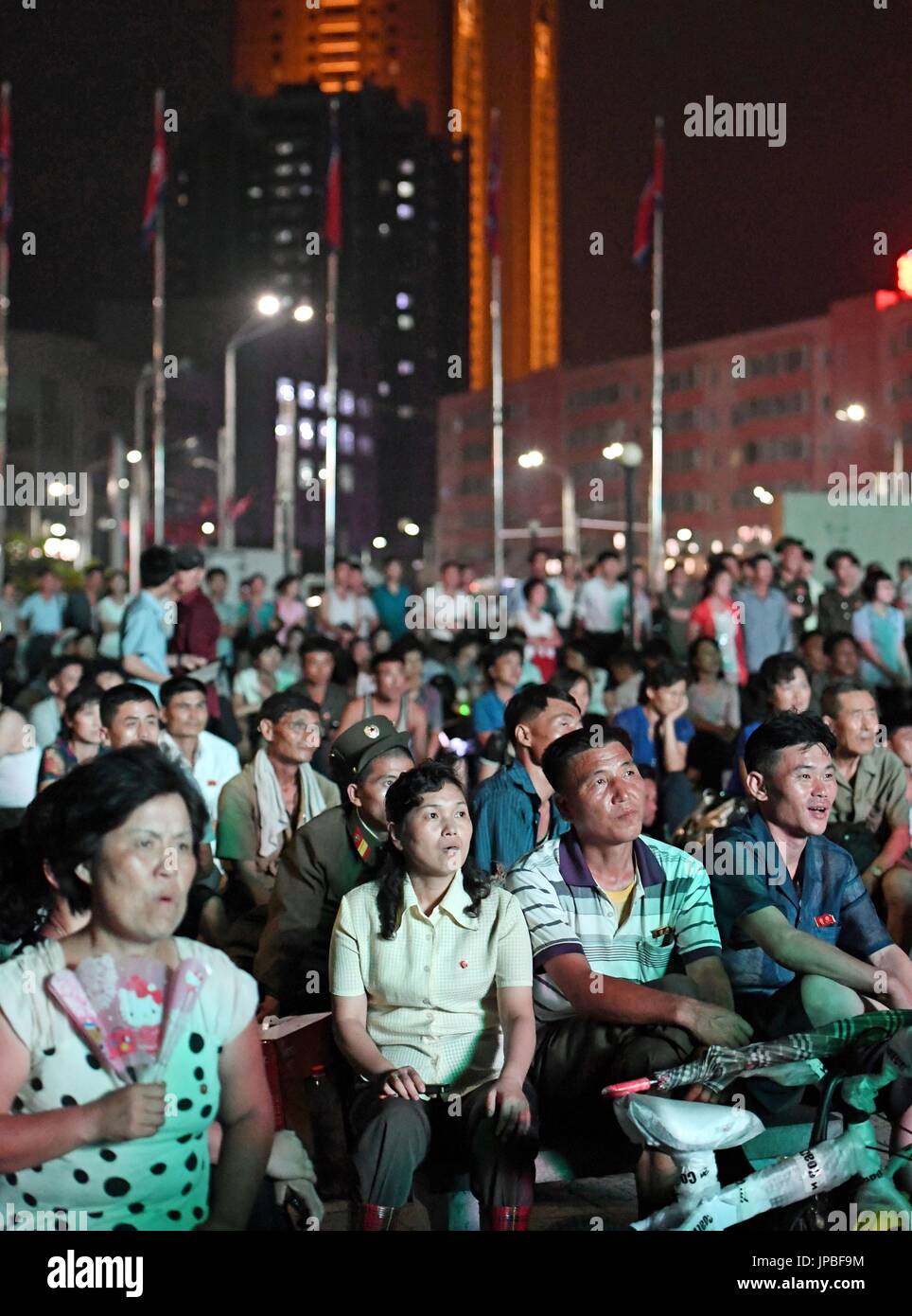 People in Pyongyang watch a large screen showing weightlifter Rim Jong ...
