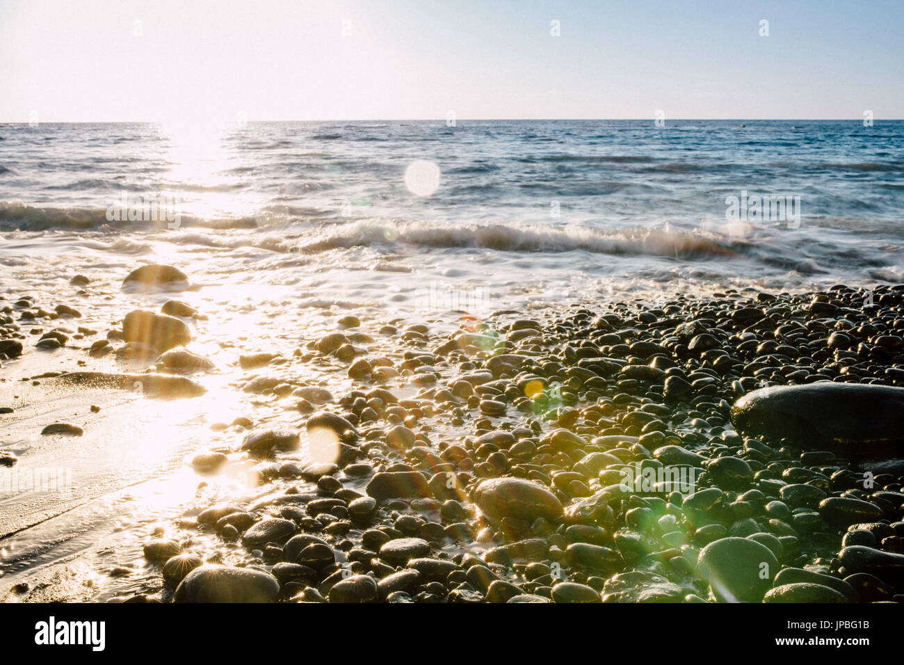 Stony beach in back light Stock Photo - Alamy