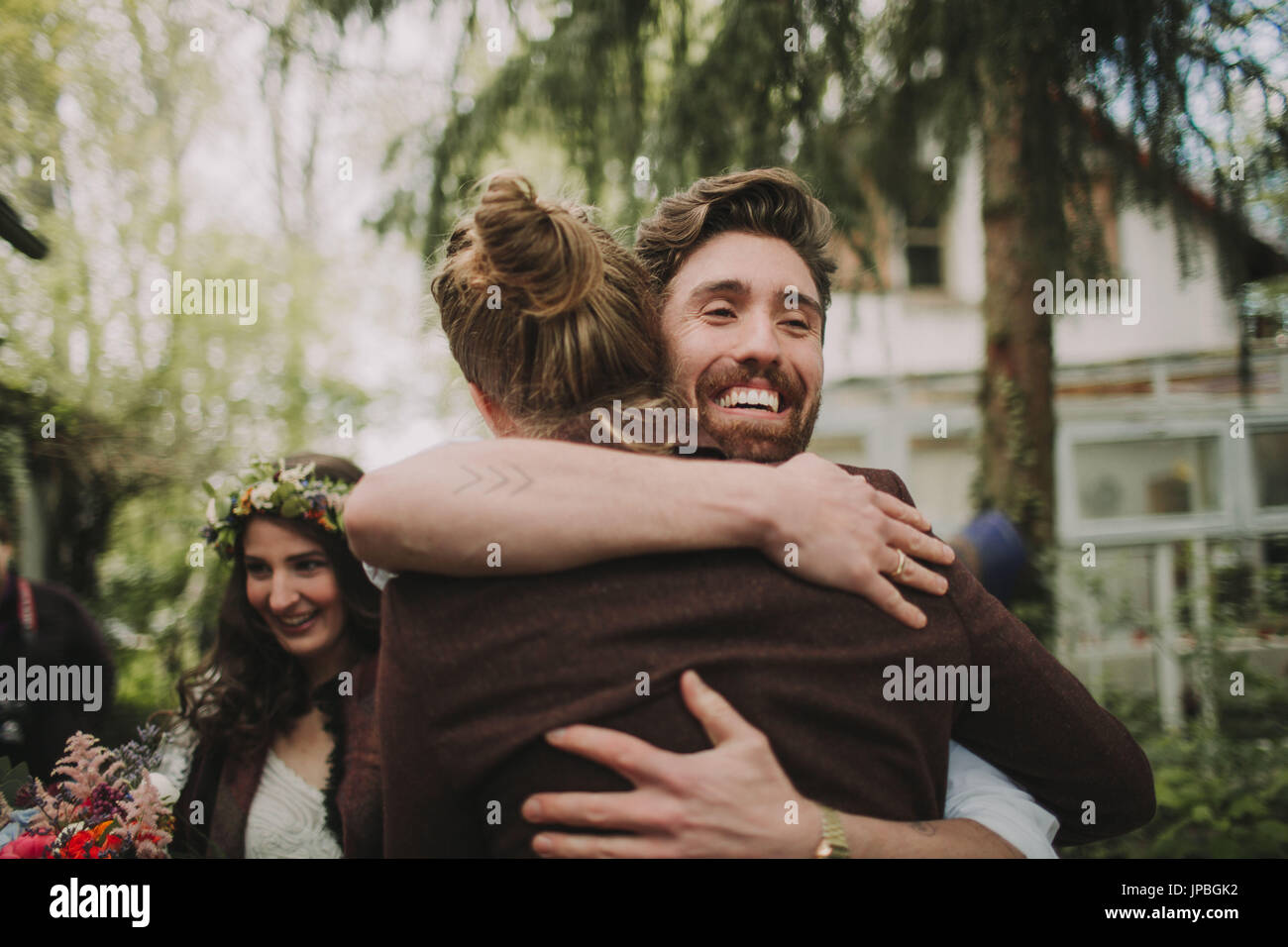 Alternative wedding, Friend hugs the groom Stock Photo - Alamy