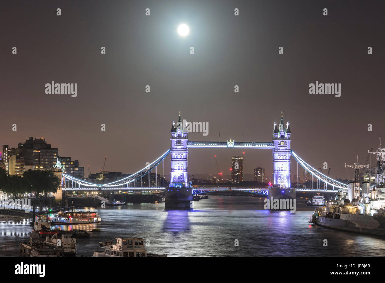 Full moon on the illuminated Tower Bridge reflected in river Thames ...
