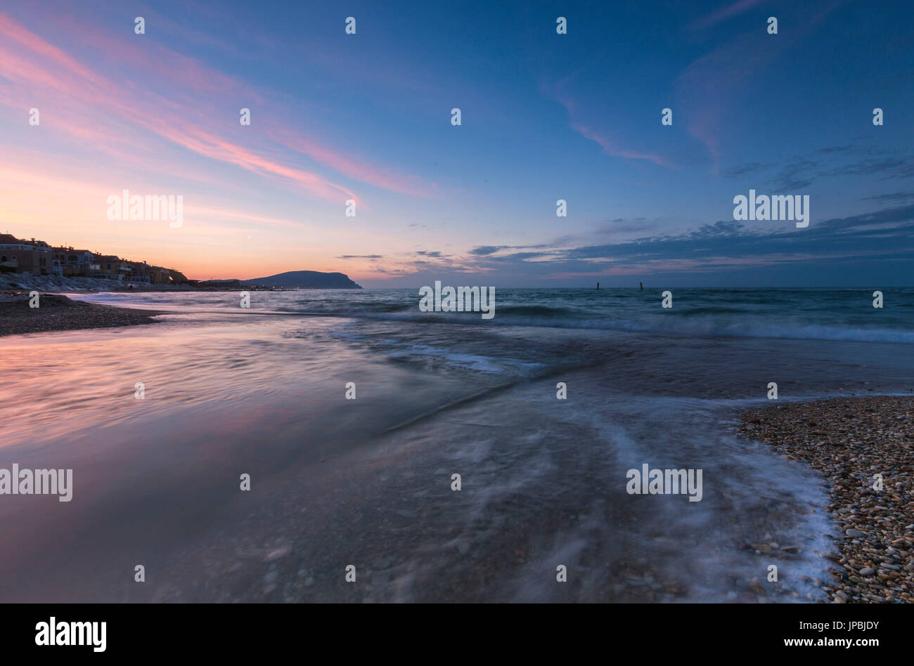 Waves crashing on the beach framed by the blue dusk Porto Recanati ...
