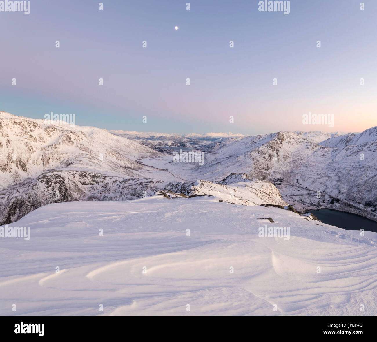 Pink sky at sunset on the snowy landscape and frozen sea surrounding ...