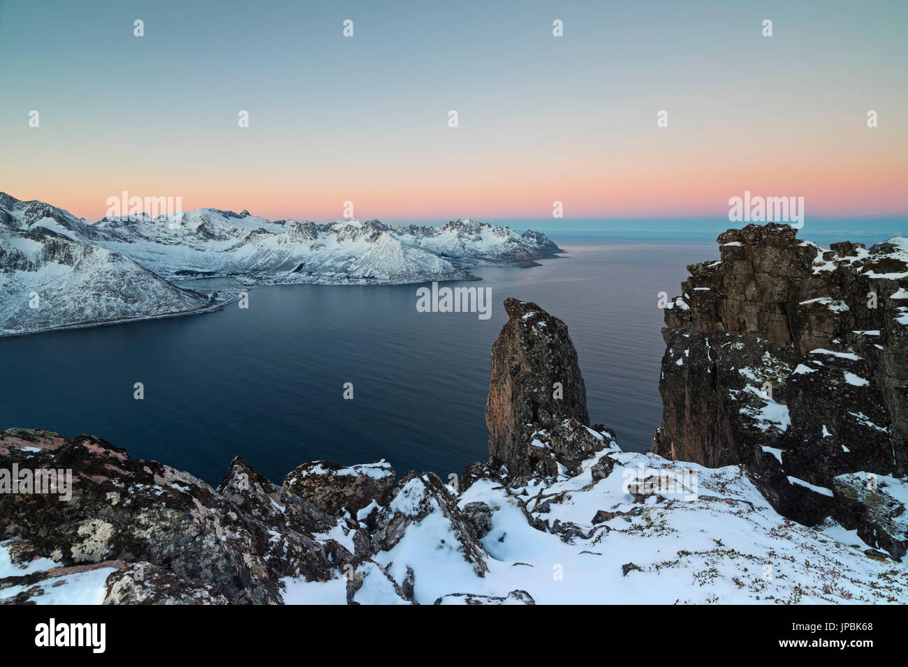 View of the Mefjorden framed by frozen sea and pink sky at sunrise from ...