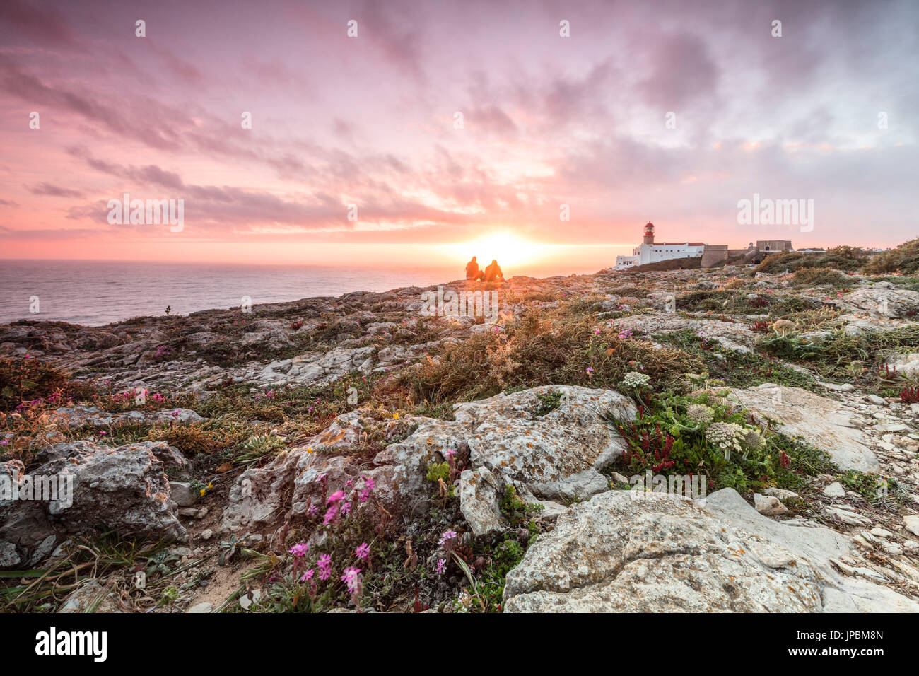 Pink sky at sunset frames the lighthouse overlooking the Atlantic Ocean ...