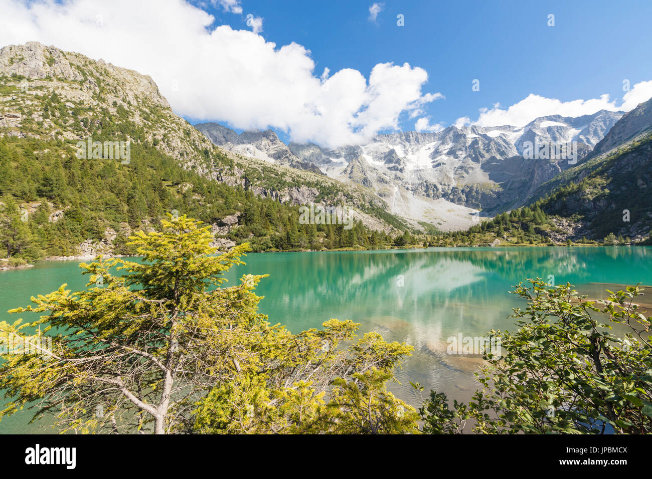 Rocky peaks and woods are reflected in Aviolo Lake Vezza D'Oglio ...