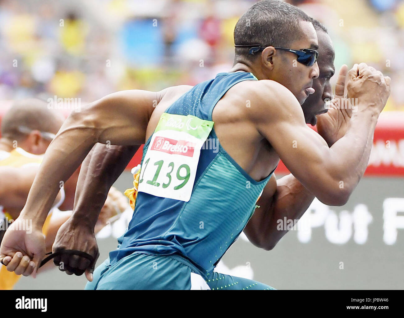 A visually impaired Brazilian athlete (front) runs alongside his guide ...