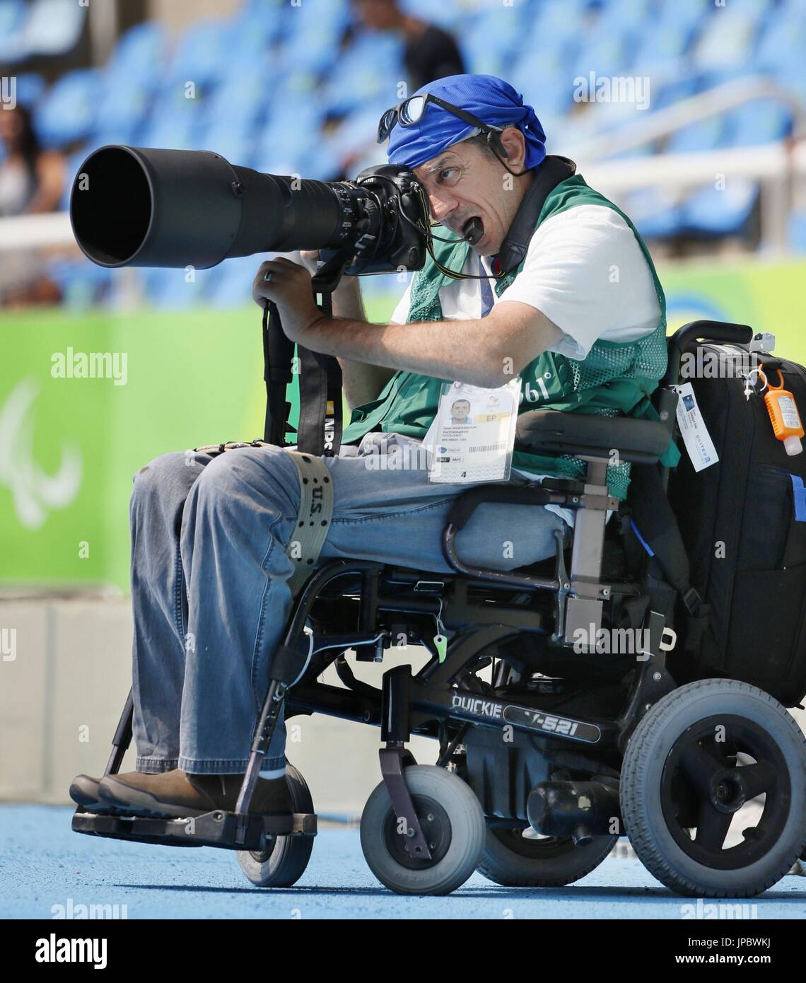 A photographer in an electric wheelchair uses a switch in his mouth to ...