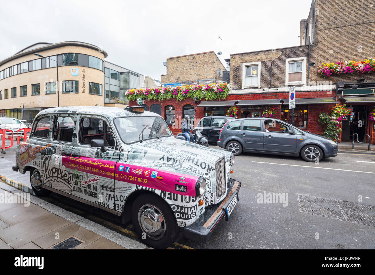 Taxi covered with advertising stickers in the shopping streets of ...