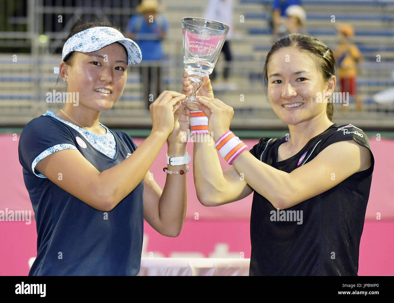 Japan's Shuko Aoyama (R) and Makoto Ninomiya hold the winners' cup for ...
