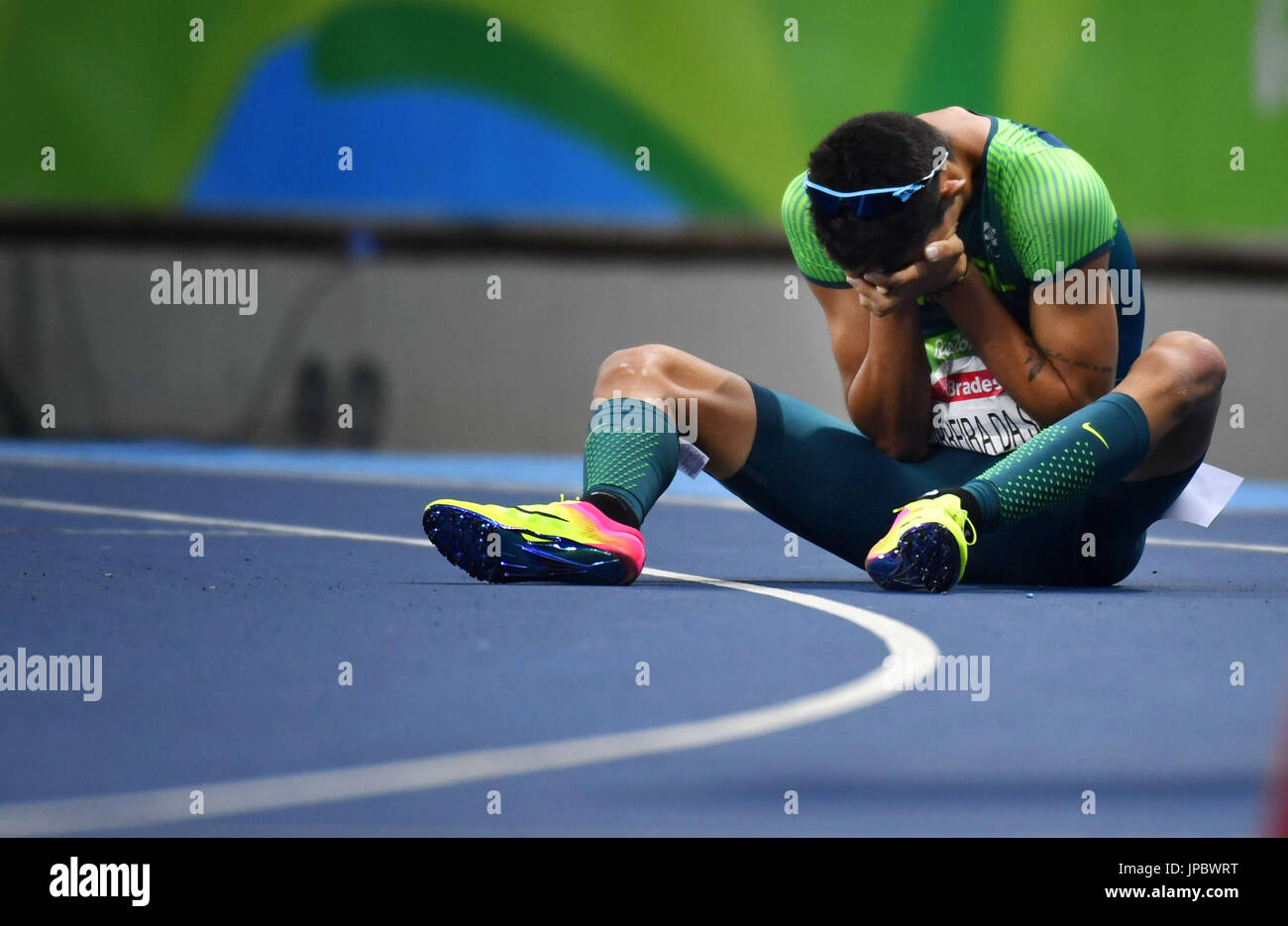 A Brazilian athlete sits on the track at the Olympic Stadium in Rio de ...
