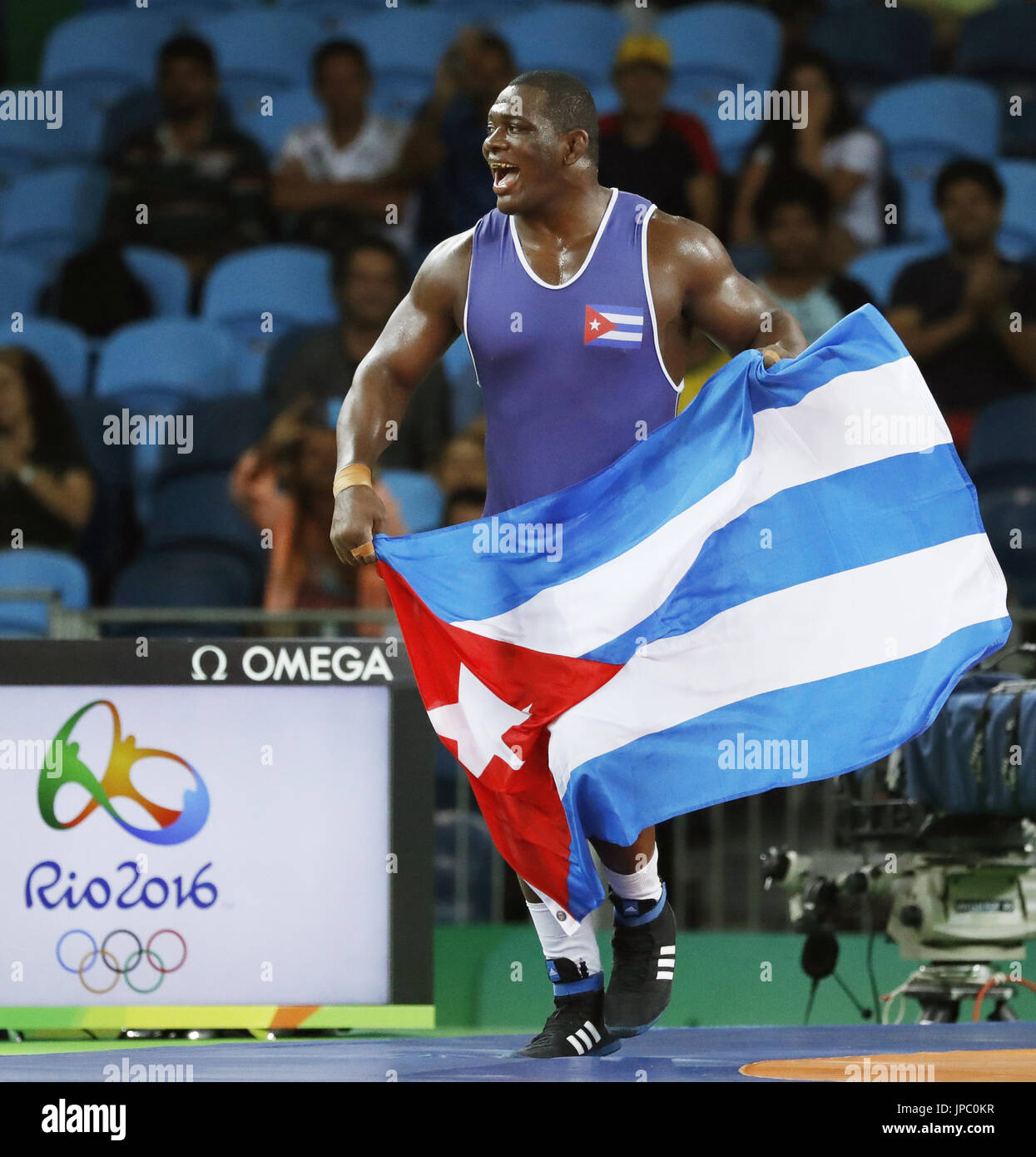 Cuban wrestler Mijain Lopez holds his country's national flag as he ...