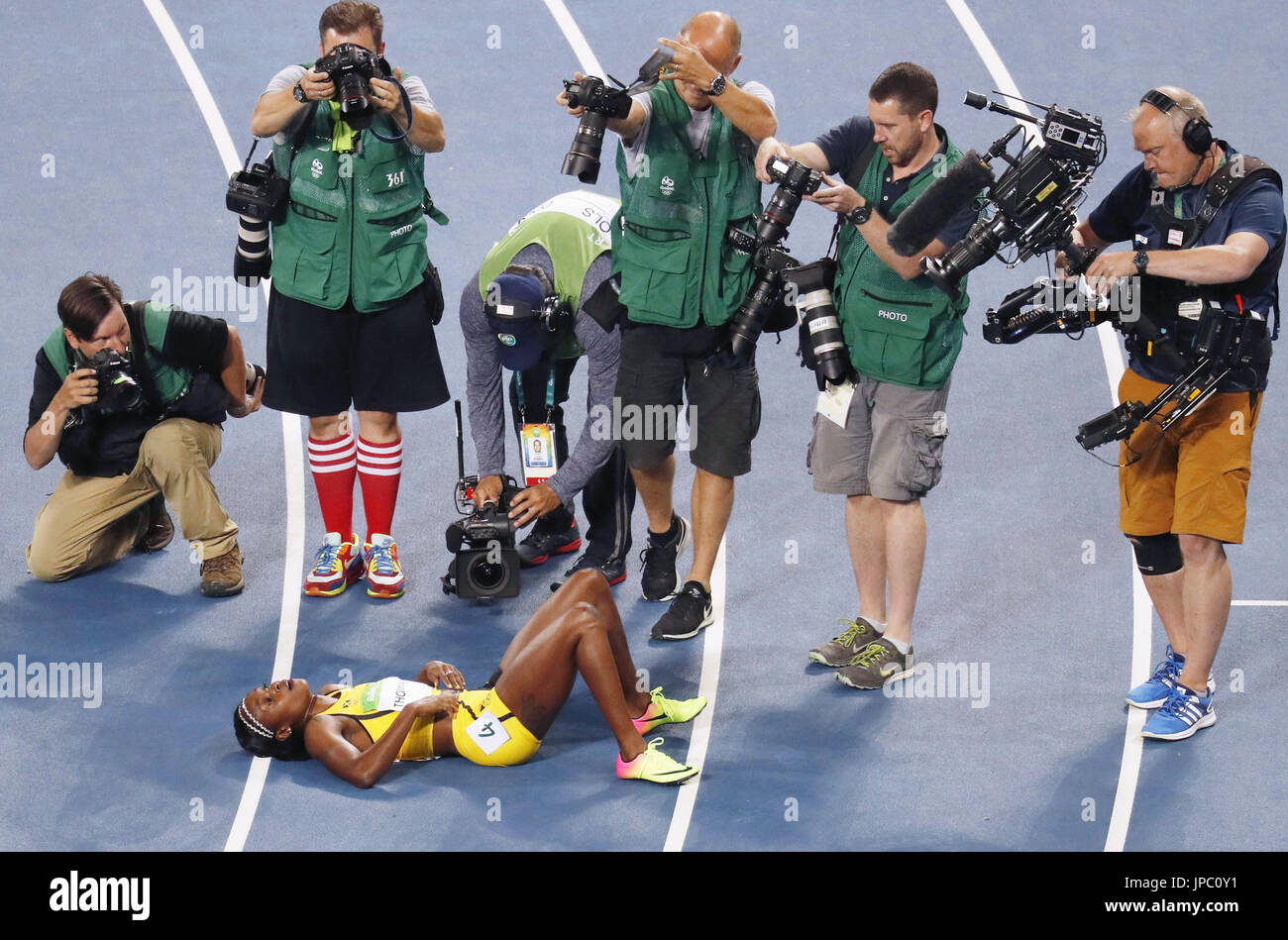 Photographers gather around Jamaican sprinter Elaine Thompson lying on ...