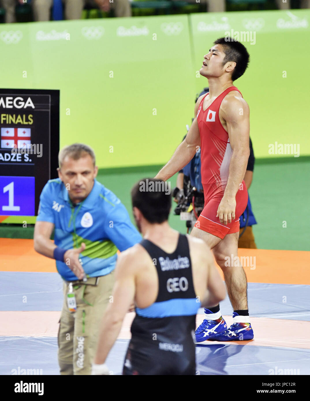 Japan's Tomohiro Inoue (R) reacts after being defeated by Shmagi Bolkvadze of Georgia (C) in a ...