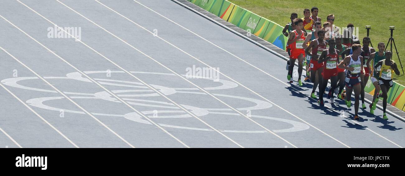 A pack of competitors run past the Olympic rings during a preliminary ...