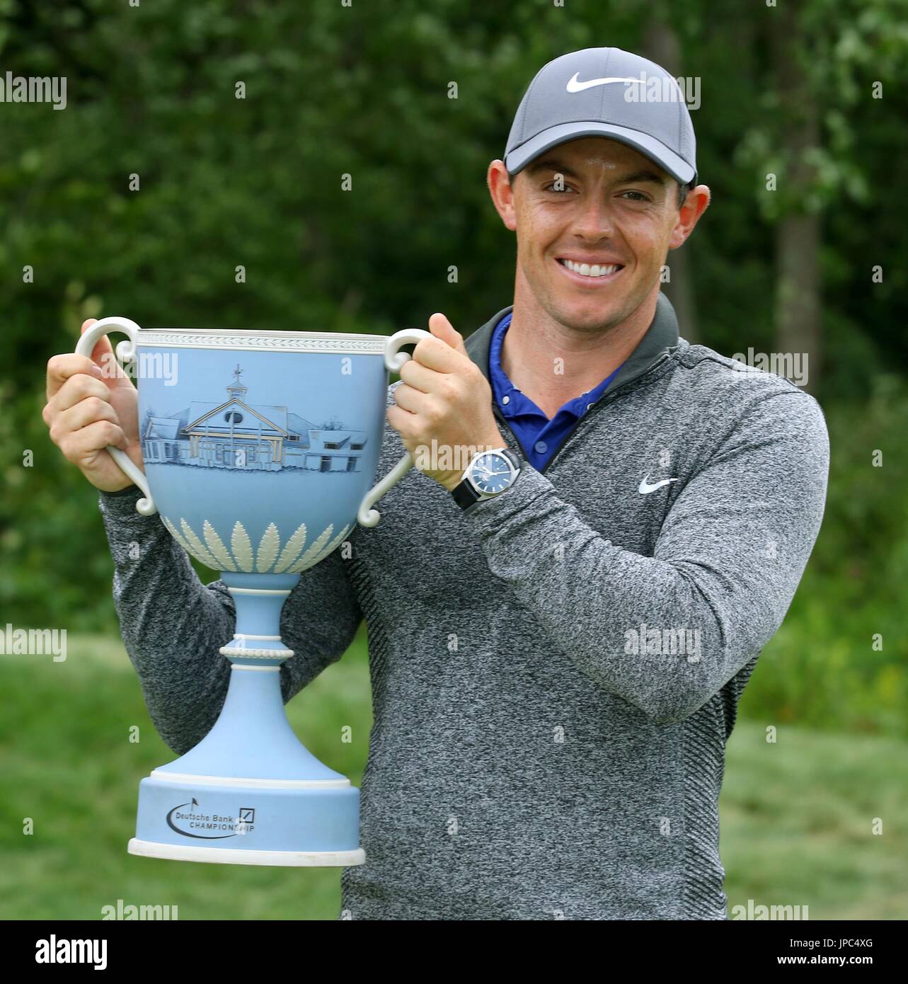 Rory McIlroy holds the winner's trophy for the Deutsche Bank ...
