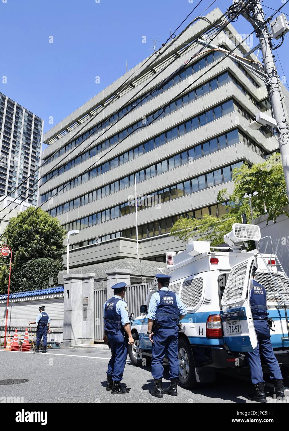 Police officers stand guard in front of the Tokyo headquarters of the ...