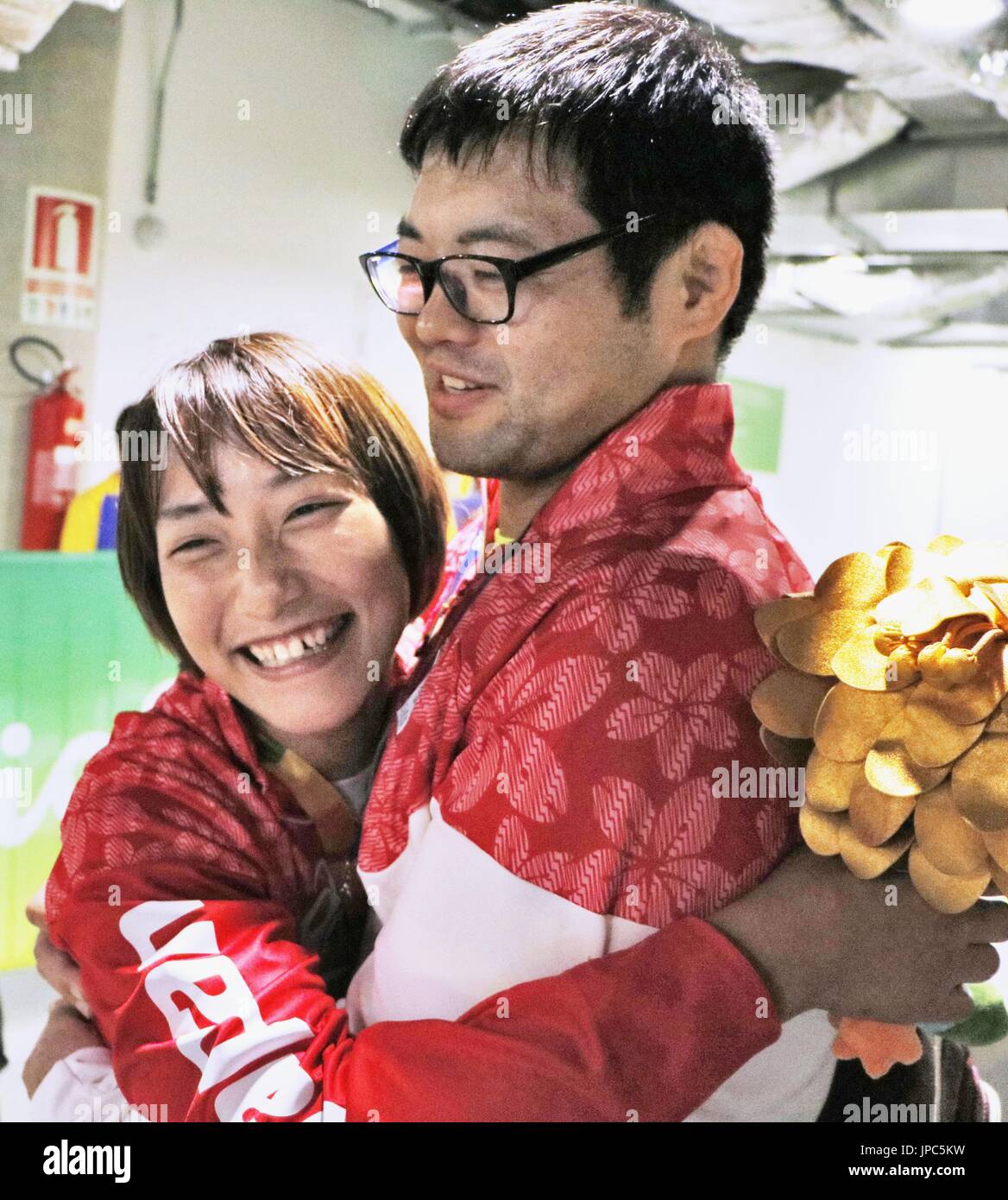 Japan's Junko Hirose (L) hugs her husband Haruka after winning the bronze medal in the 57 ...
