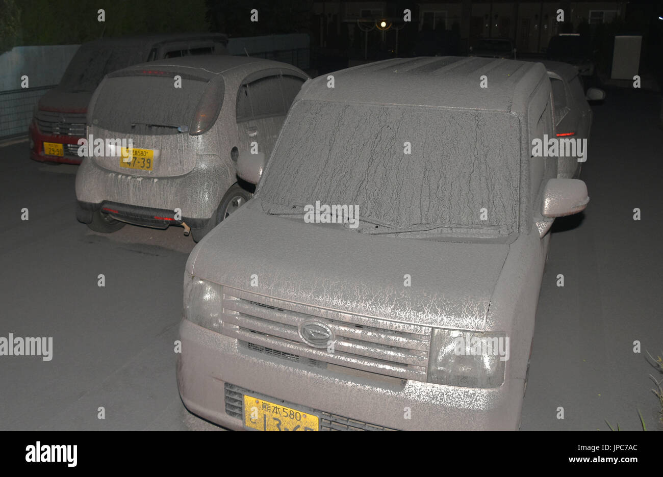 Vehicles are covered by volcanic ash from Mt. Aso in Kumamoto ...