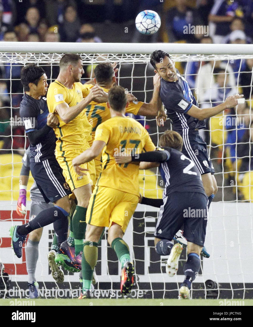 Maya Yoshida of Japan (R) heads to clear the ball during the first half ...