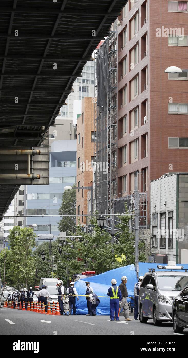 Police officers investigate at the site where an iron pipe fell from ...