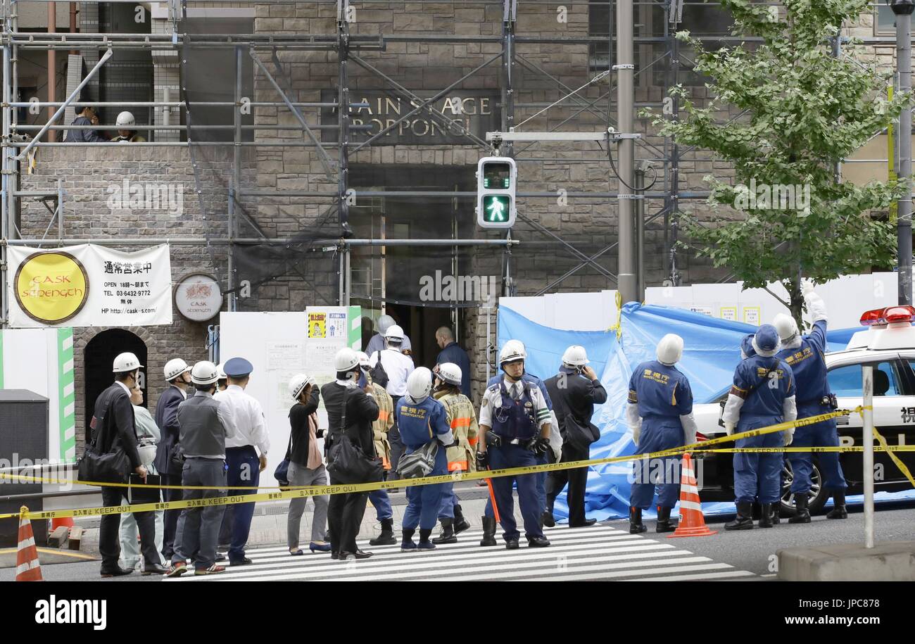 Police officers investigate at the site where an iron pipe fell from ...