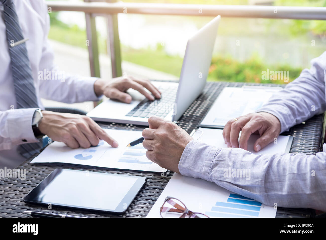 Business people discuss together about there work by graph document and ...