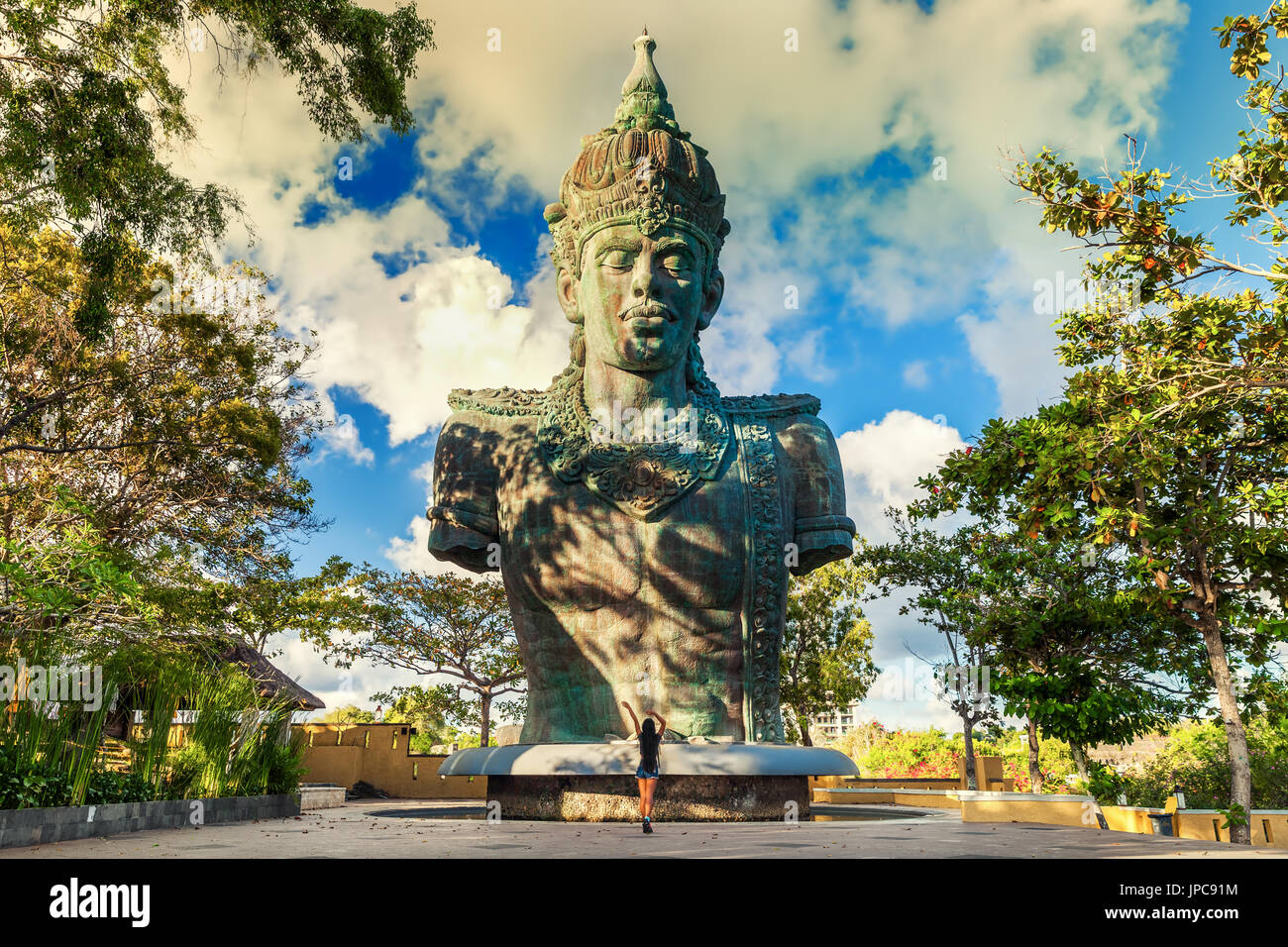 Young beautiful woman traveller enjoy spectacular view traditional hindu architecture in Garuda ...