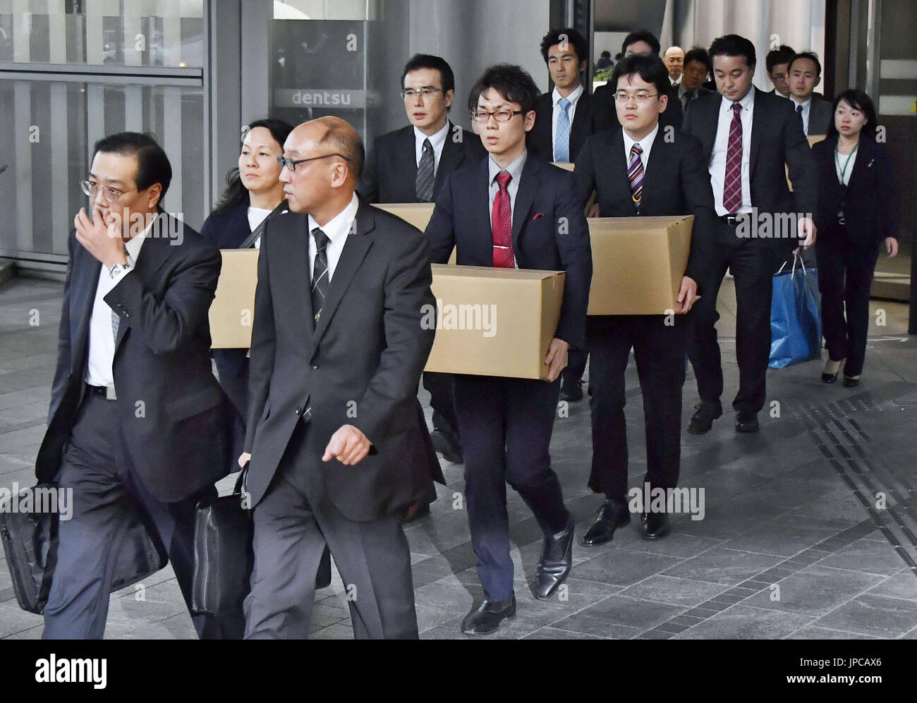 Labor authorities leave the headquarters in Tokyo of Dentsu Inc., the ...