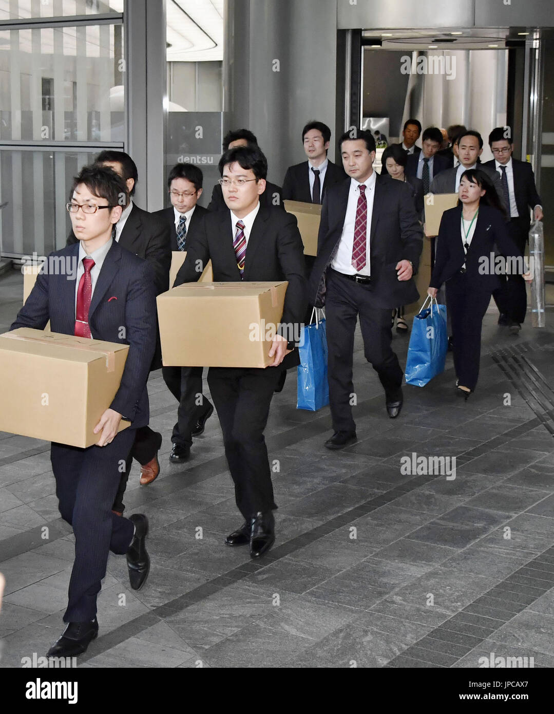 Labor authorities leave the headquarters in Tokyo of Dentsu Inc., the ...
