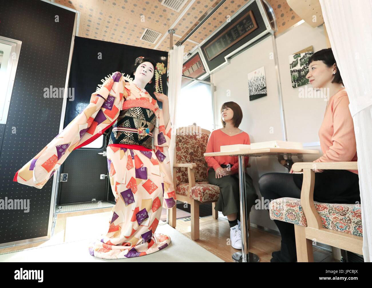 A geisha gives a preview of a dance performance inside a train carriage ...