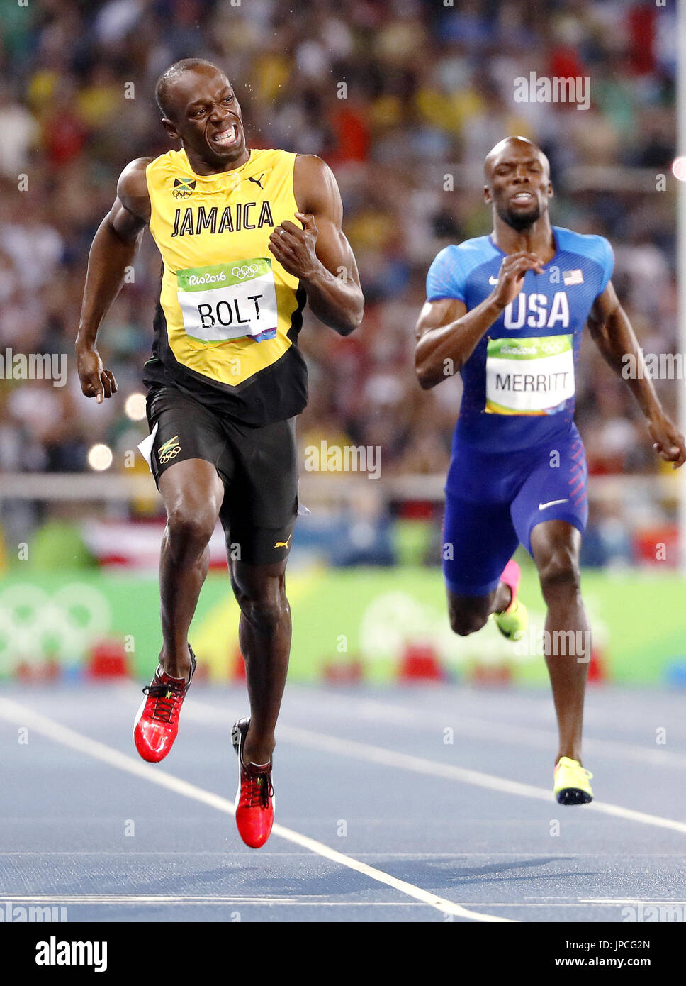 Usain Bolt (L) of Jamaica crosses the finish line to win the gold medal ...