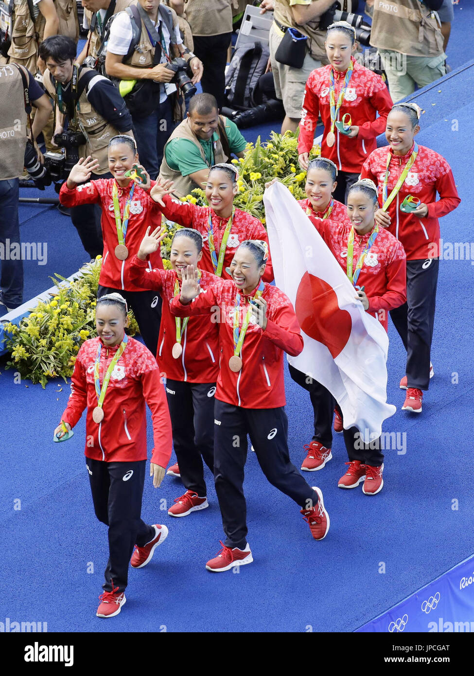 The members of Japan's synchronized swimming team smile and acknowledge ...